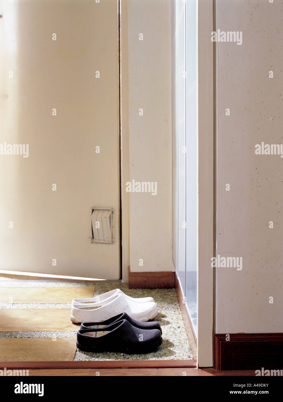 High angle view of two pairs of shoes near a door Stock Photo - Alamy