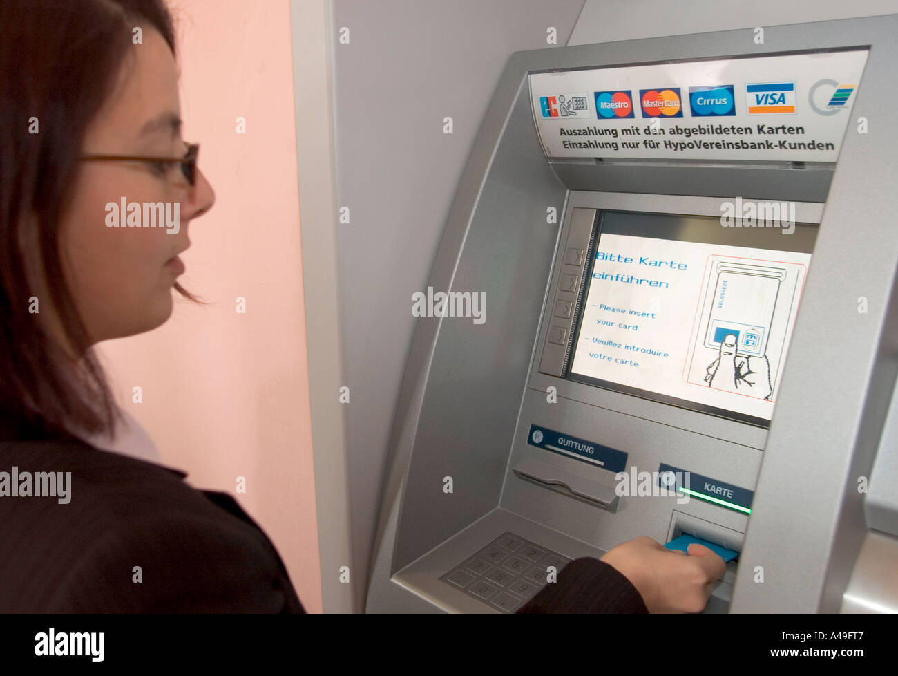 Woman at cash dispenser Stock Photo - Alamy