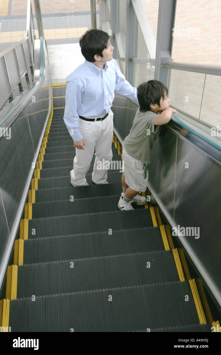 Young man and his son on an escalator Stock Photo - Alamy