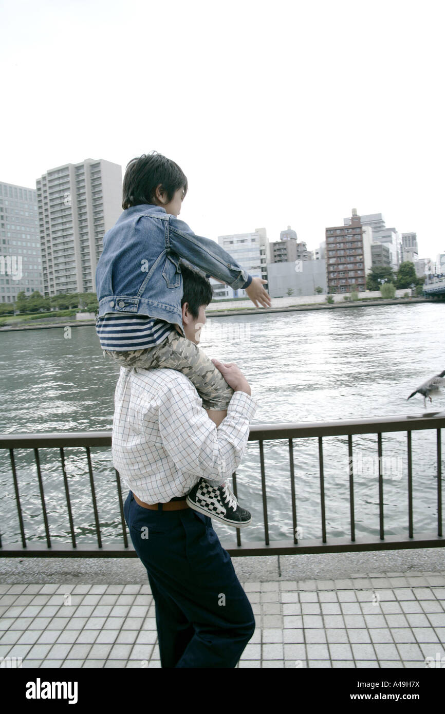Side profile of a man carrying his son on his shoulders Stock Photo - Alamy