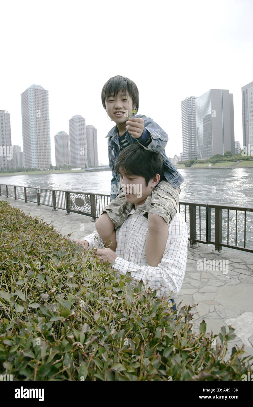 Young man carrying his son on his shoulders Stock Photo - Alamy