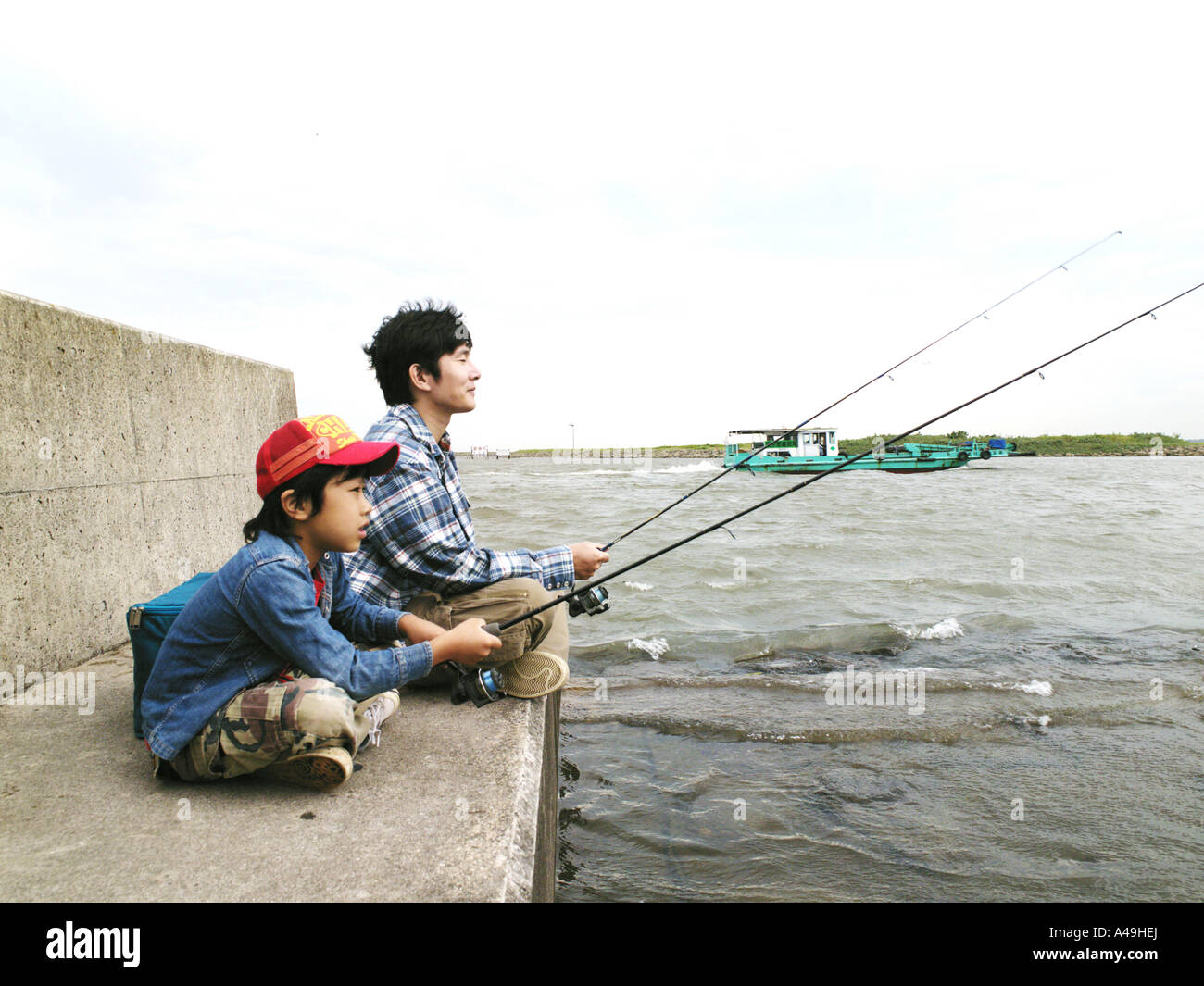 Side profile of a young man and his son fishing in a river Stock Photo ...