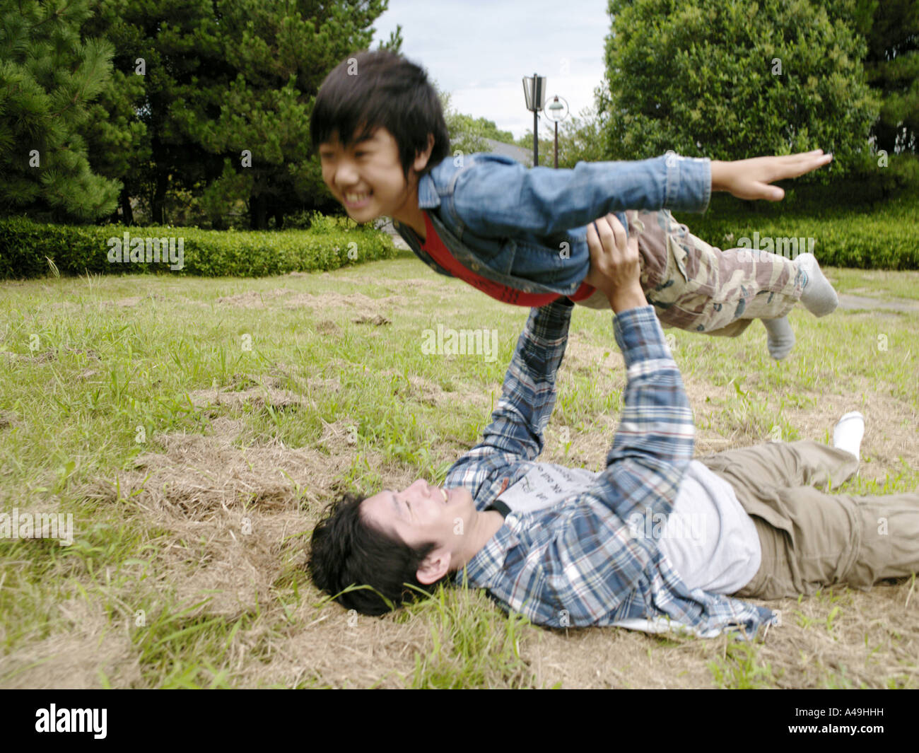Young man lifting his son Stock Photo - Alamy