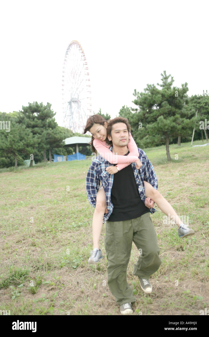 Young woman riding piggyback on a young man Stock Photo - Alamy