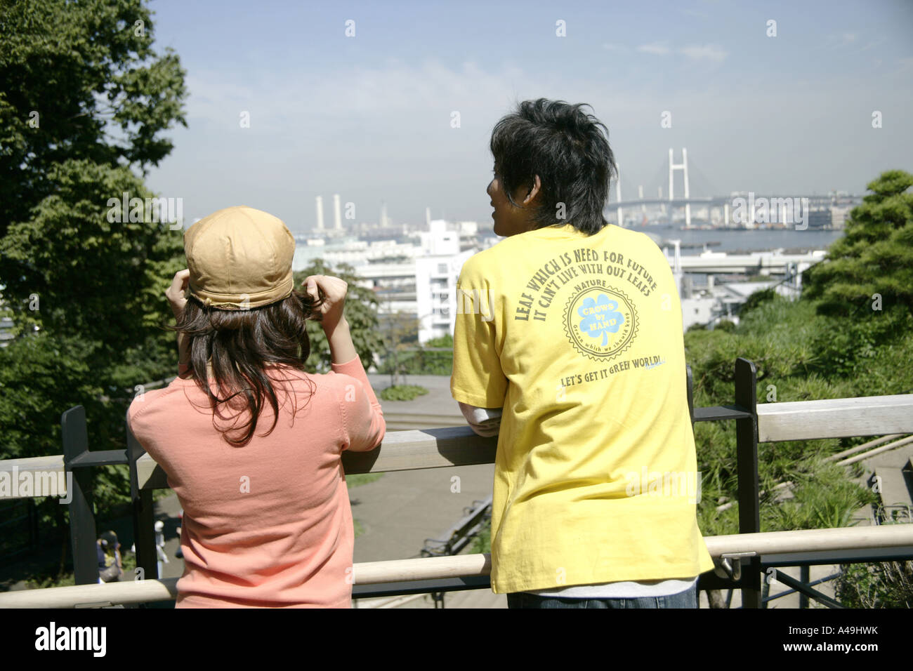 Rear view of a man and a woman standing against a railing Stock Photo ...