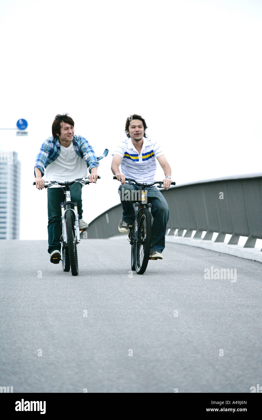 Two young men riding bicycles Stock Photo - Alamy