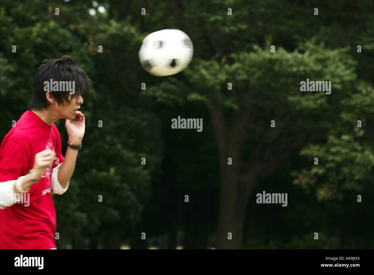 Side profile of a young man heading the ball Stock Photo - Alamy