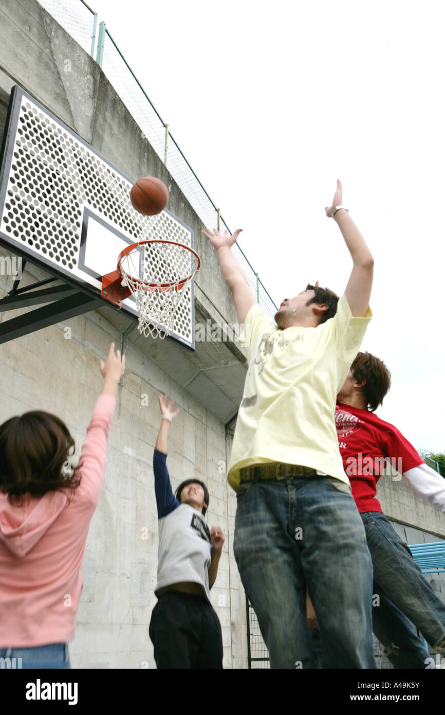 Low angle view of five people shooting a basket ball into a hoop Stock ...