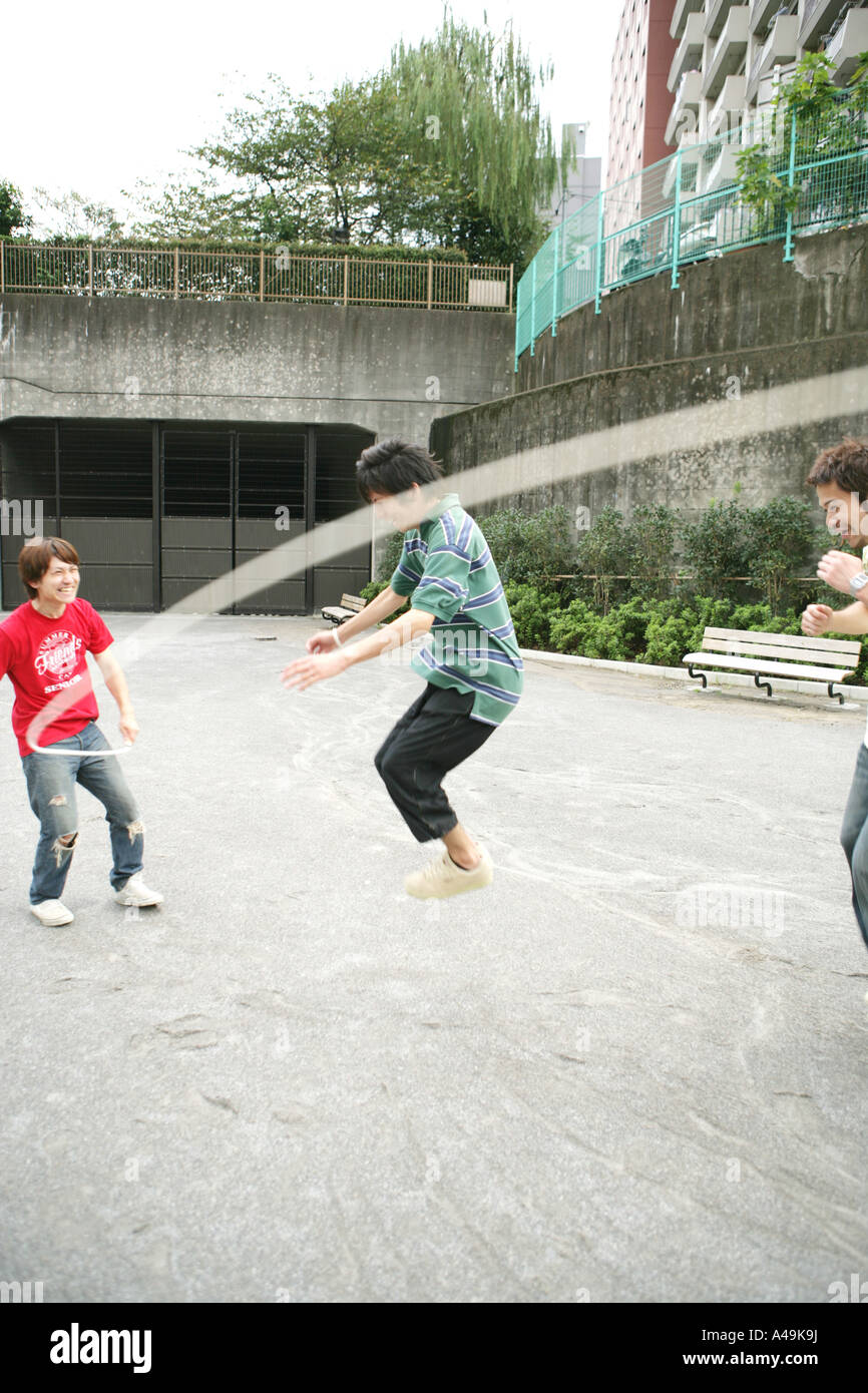 Three young men playing jump rope Stock Photo - Alamy