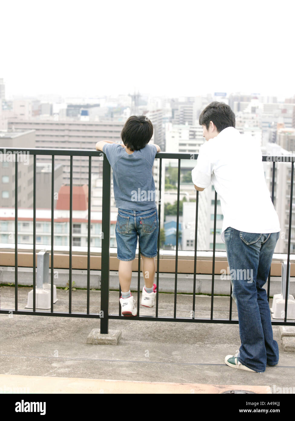 Rear view of two people holding a railing Stock Photo - Alamy