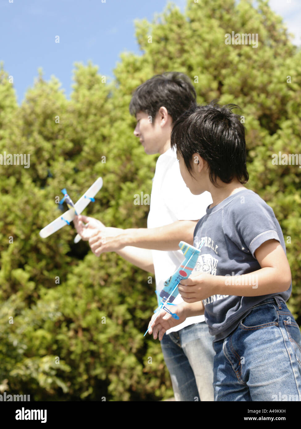 Low angle view of a father and his son holding model airplanes Stock ...