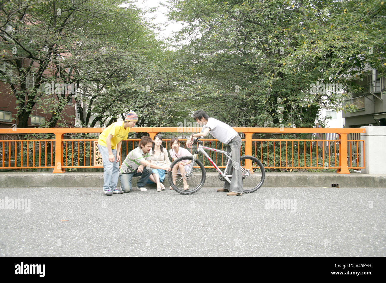 Young man sitting on a bicycle with four friends beside him Stock Photo ...
