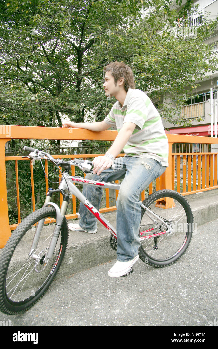 Side profile of a young man sitting on bicycle and looking away Stock ...