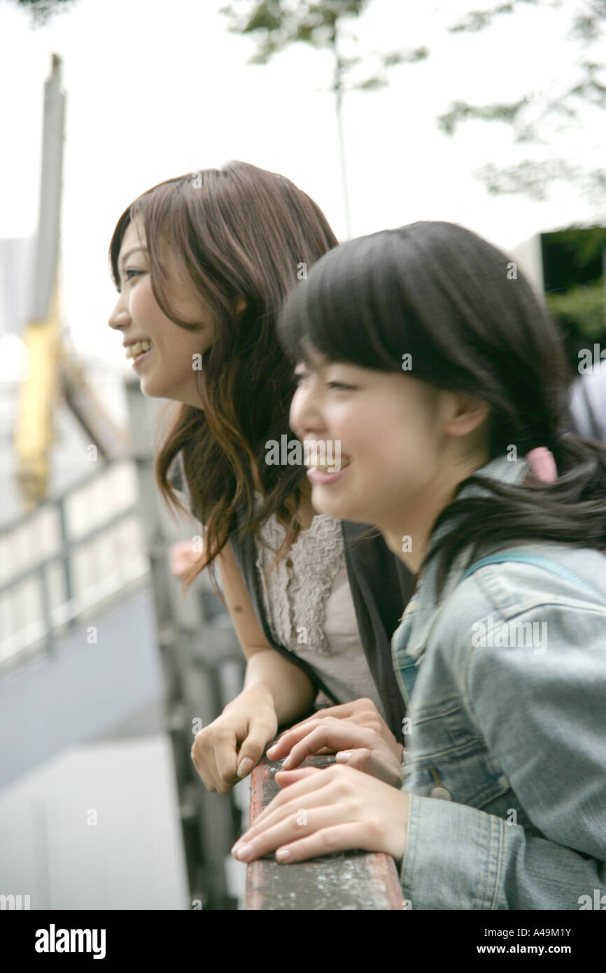 Side profile of two young women smiling Stock Photo - Alamy