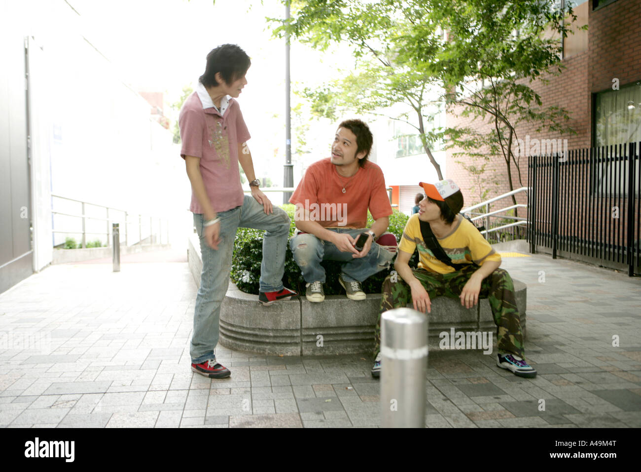 Three young men sitting together and talking Stock Photo - Alamy