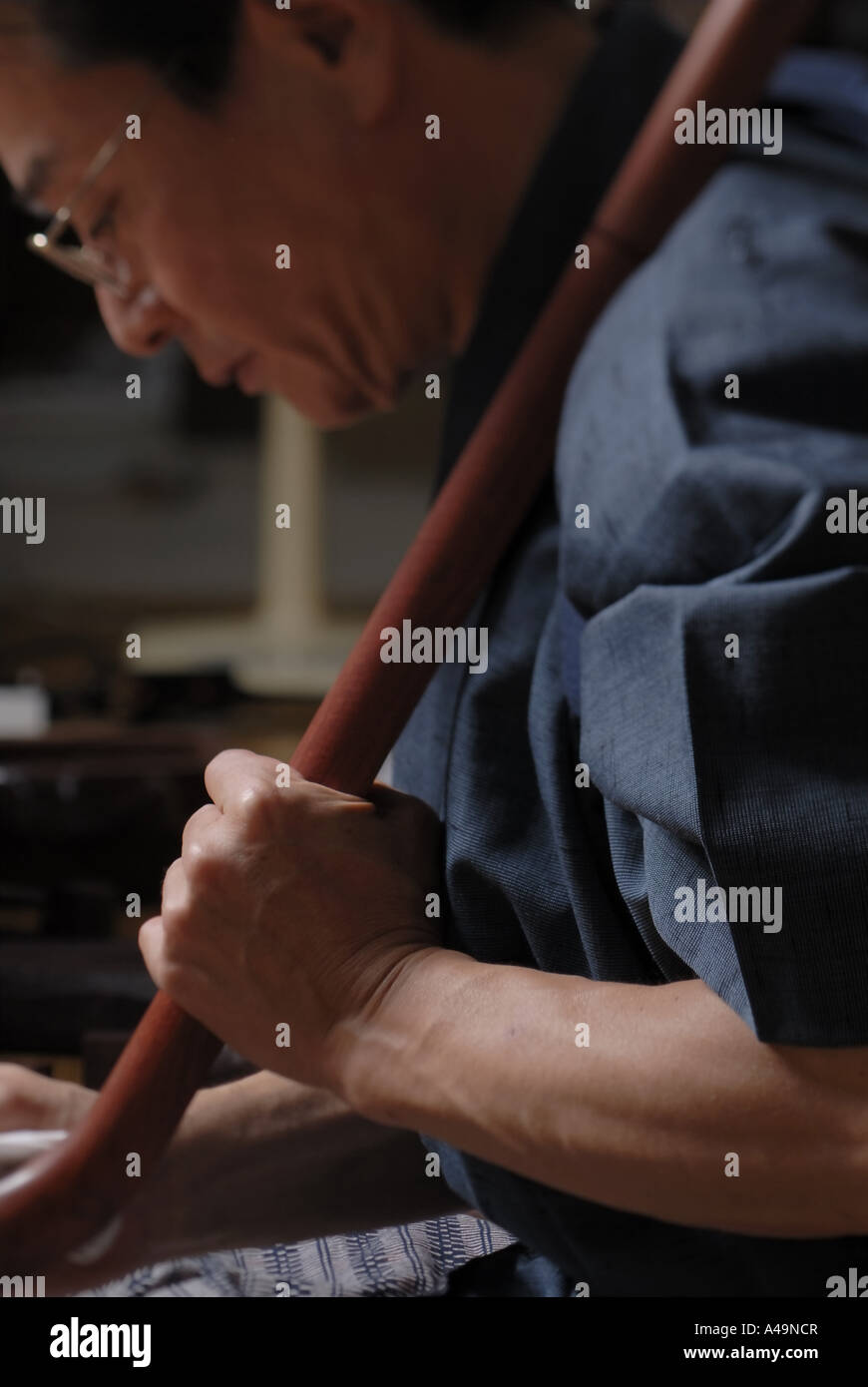 Side profile of a carpenter working on a wooden stick Stock Photo - Alamy