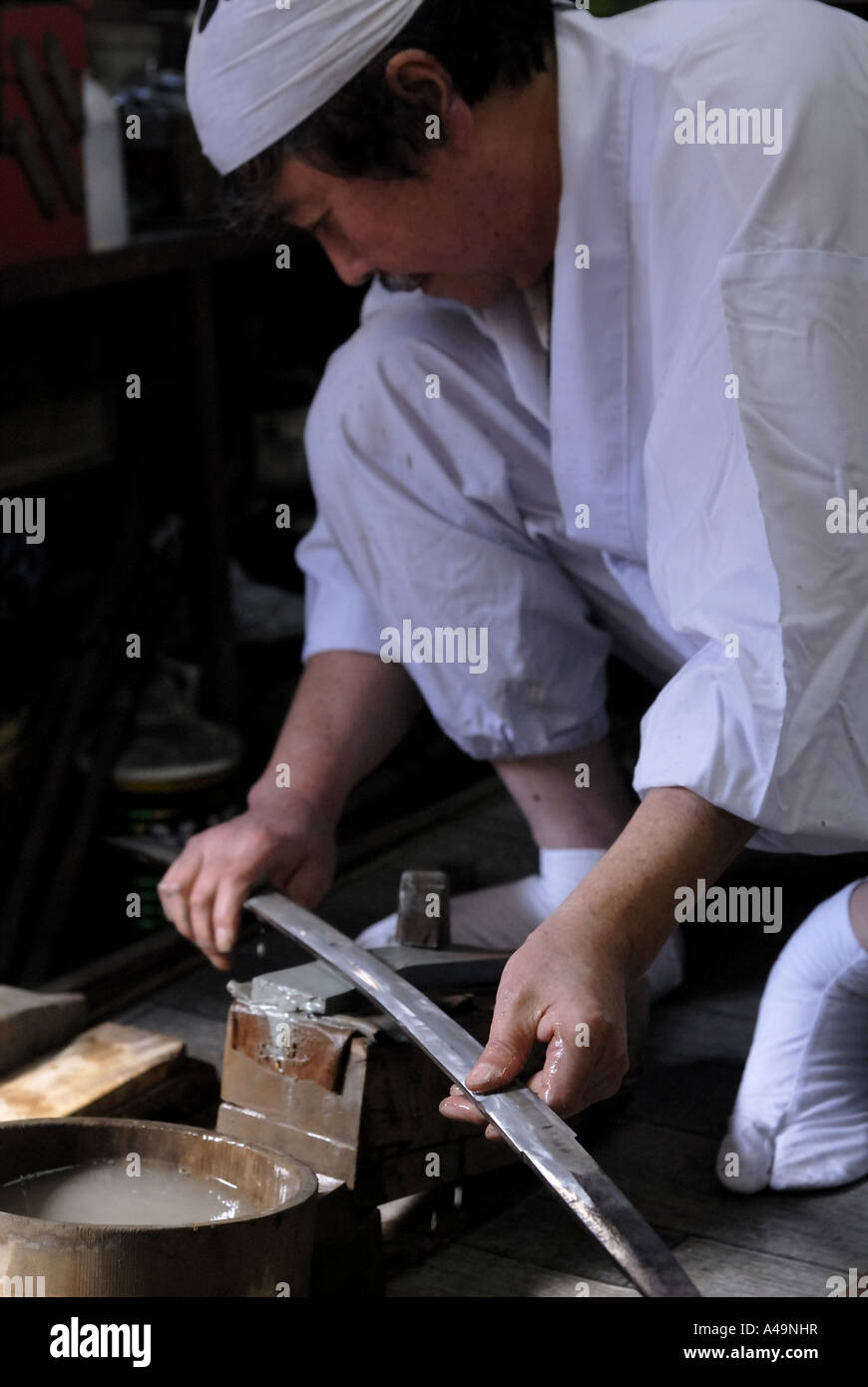 Side profile of a blacksmith sharpening a sword Stock Photo - Alamy