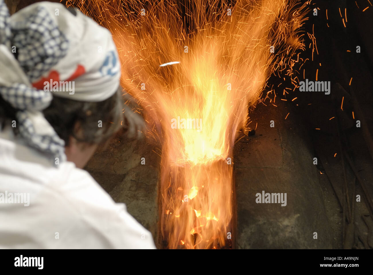 Rear view of a blacksmith in front of a furnace Stock Photo - Alamy
