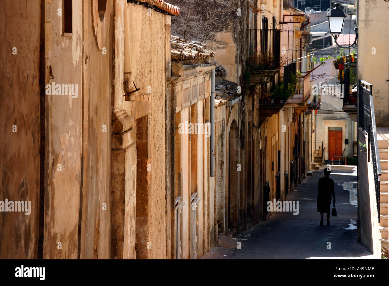 A woman walks down a side street in the town of Palazzolo Acreide ...