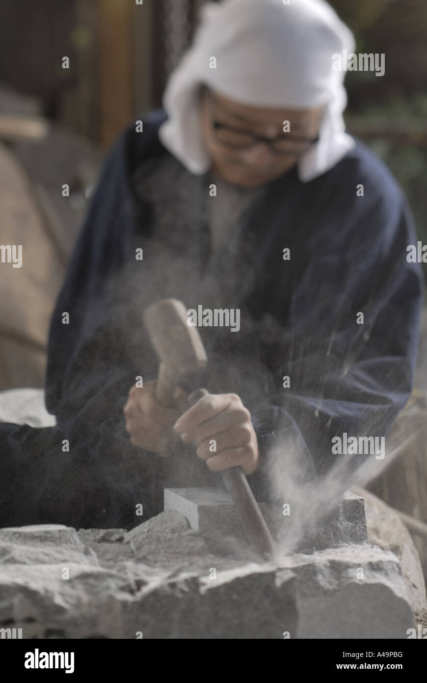 Sculptor carving a stone with a chisel and a hammer Stock Photo - Alamy