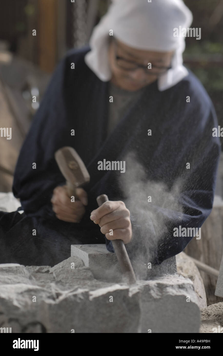 Sculptor carving a stone with a chisel and a hammer Stock Photo - Alamy