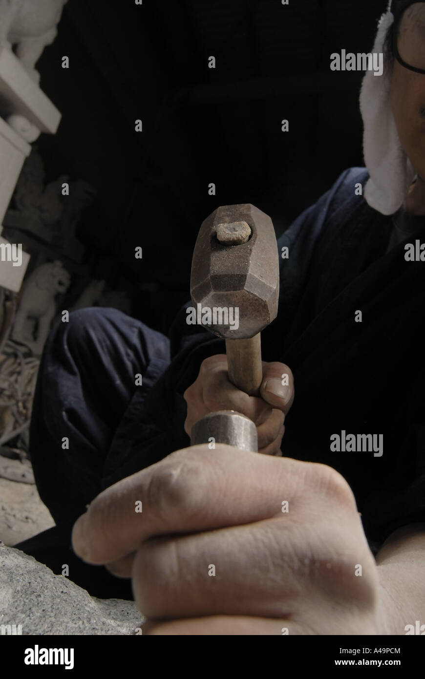 Sculptor carving a stone with a chisel and a hammer Stock Photo - Alamy