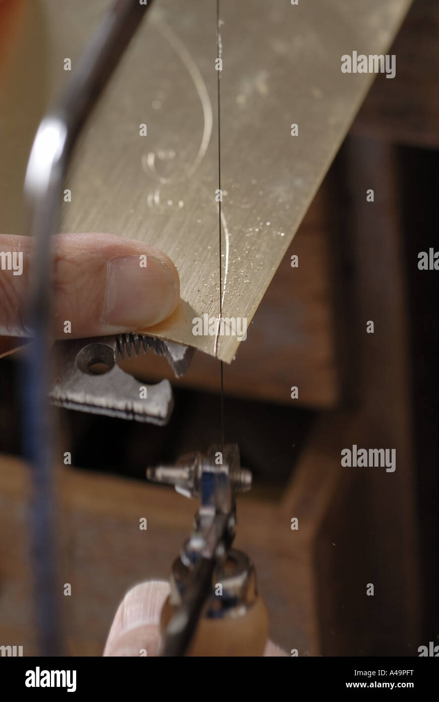 Close up of a person s hands cutting metal sheet with a hacksaw blade ...