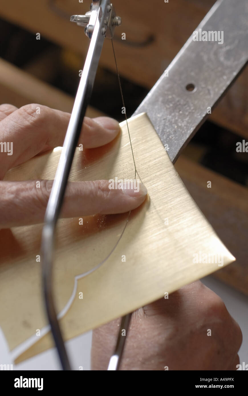 Close up of a human hand cutting a metal sheet with a hacksaw blade ...