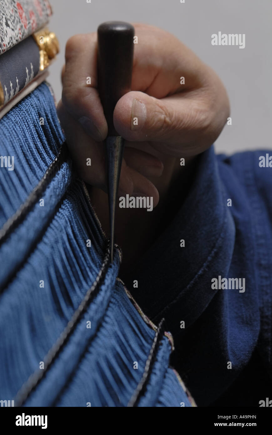 Close up of a person s hand making a traditional costume with a work ...
