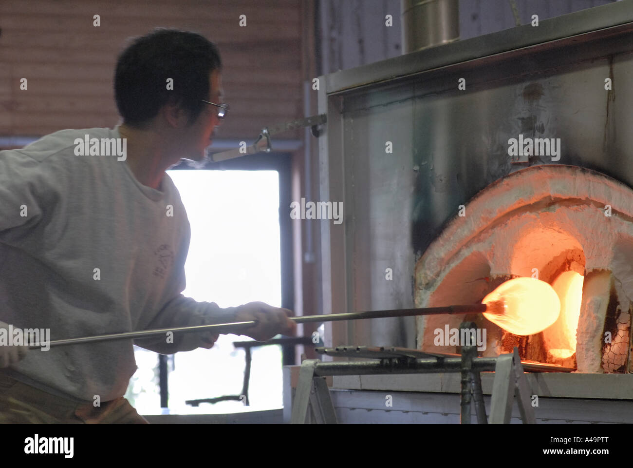 Side profile of a mid adult man molding a glass bulb Stock Photo - Alamy