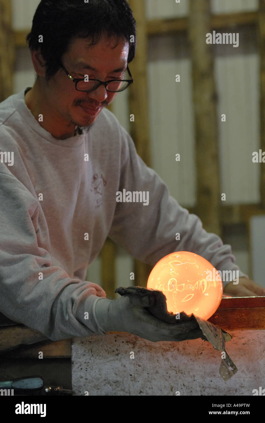 Close up of a mid adult man molding a glass bulb Stock Photo - Alamy