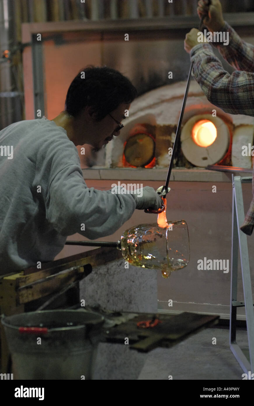 Side profile of two mid adult men molding glass Stock Photo - Alamy