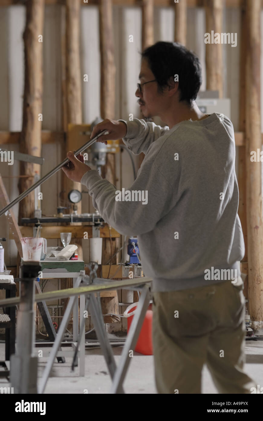 Rear view of a mid adult man holding an iron rod Stock Photo - Alamy