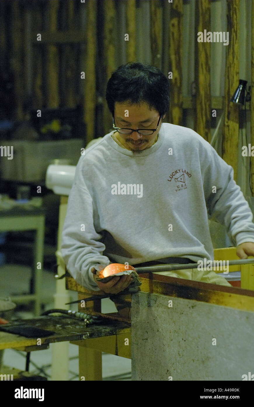 Mid adult man molding a glass bulb Stock Photo - Alamy