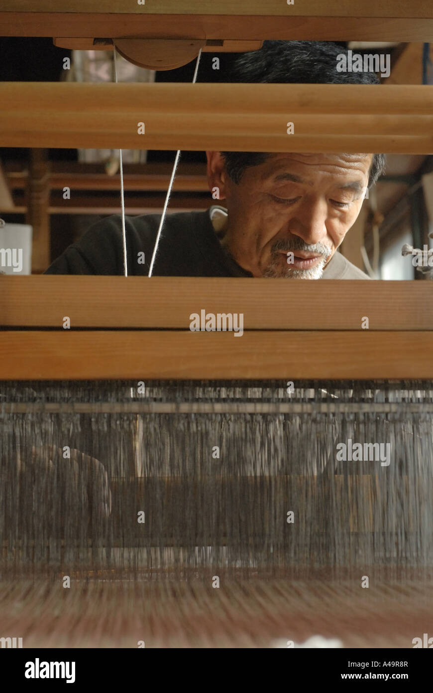 Mature man working on a loom Stock Photo - Alamy