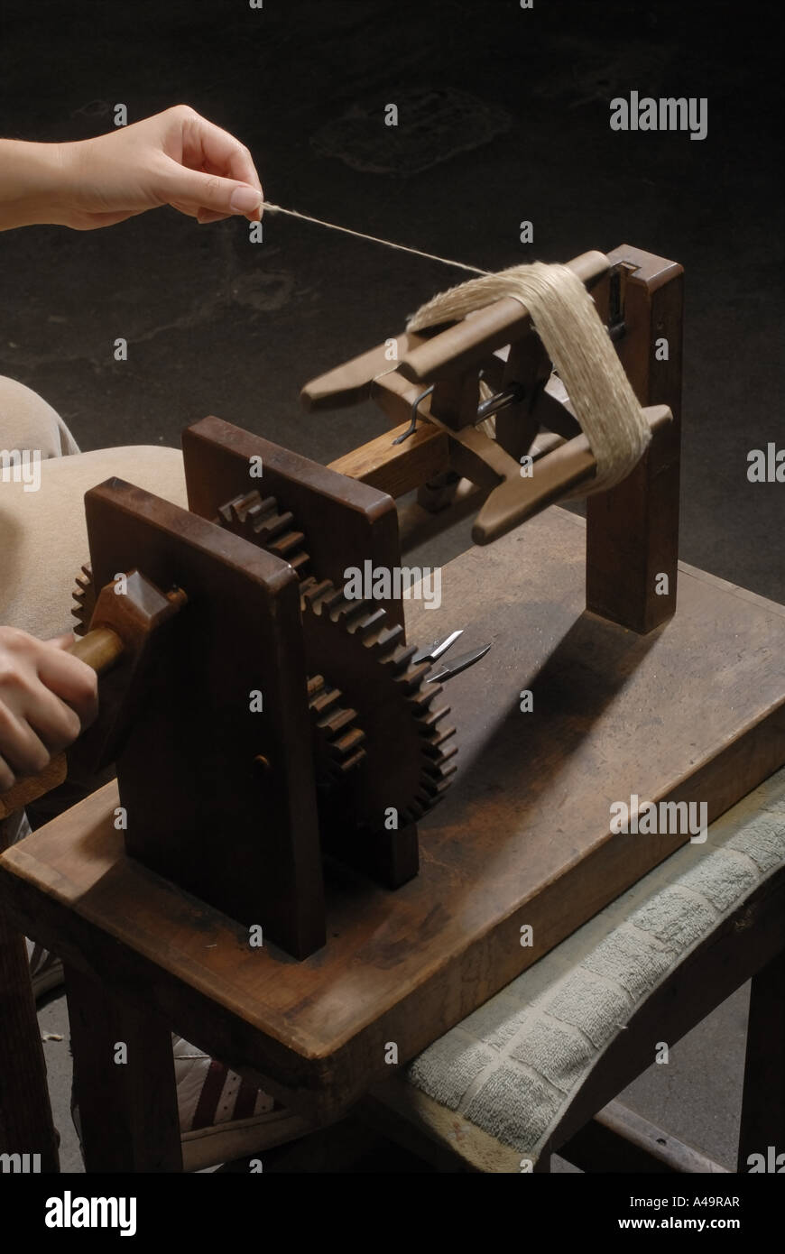 Close up of a person s hand working on a spinning wheel Stock Photo - Alamy