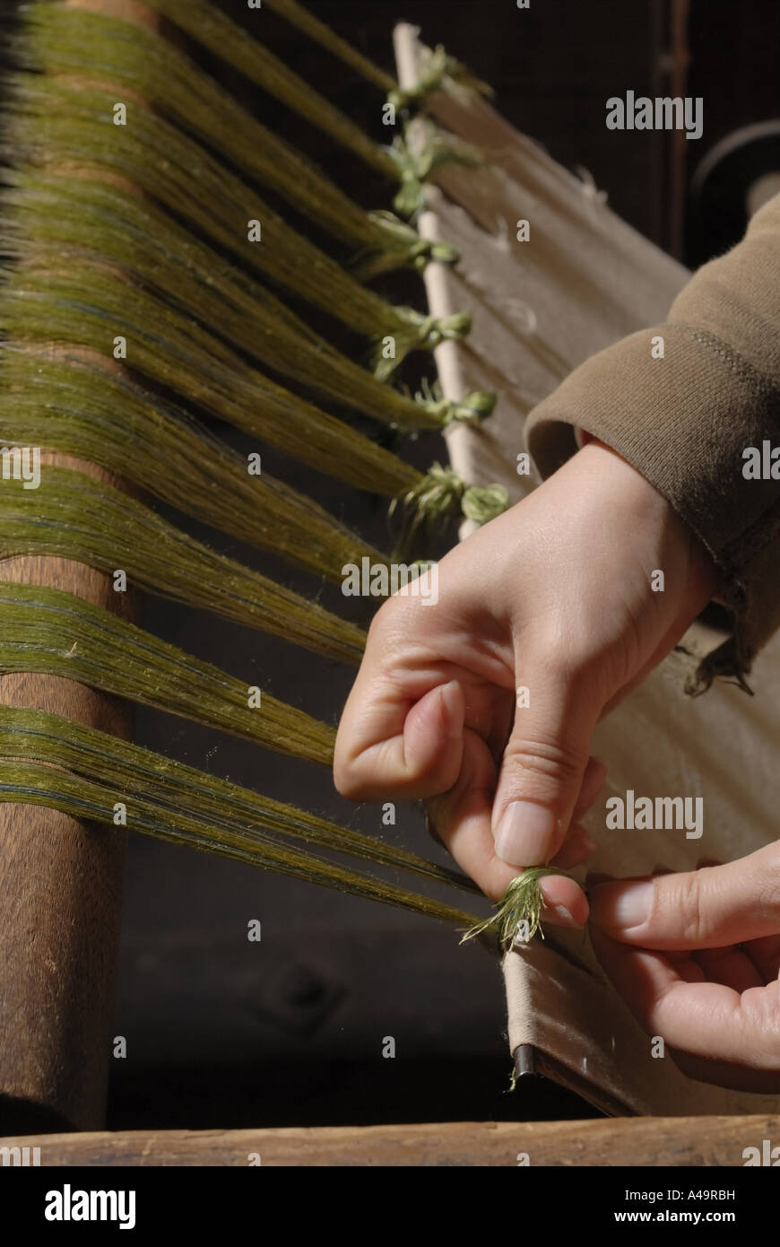Close up of a person s hands tying threads on a loom Stock Photo - Alamy