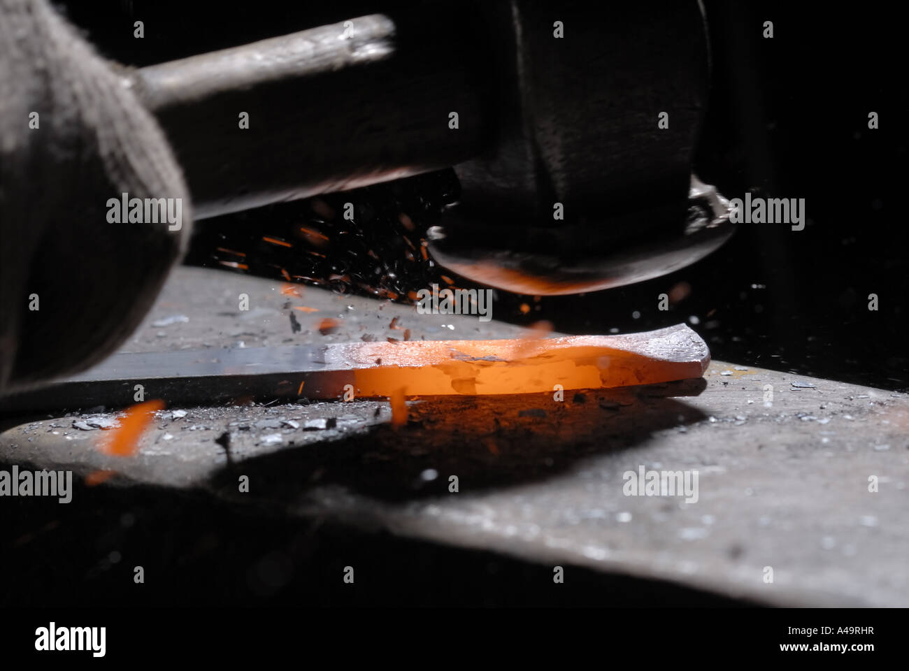Close up of a person s hand hitting molten metal with a hammer Stock ...