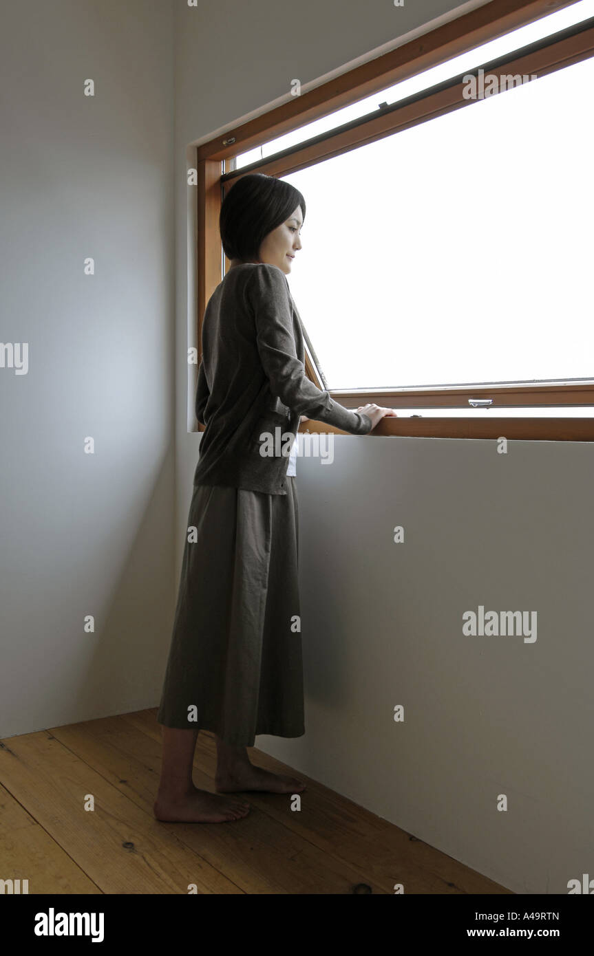 Side profile of a young woman looking through a window Stock Photo - Alamy