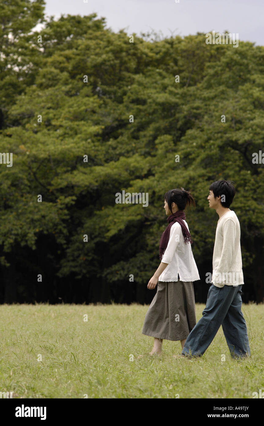 Side profile of a young couple walking together Stock Photo - Alamy