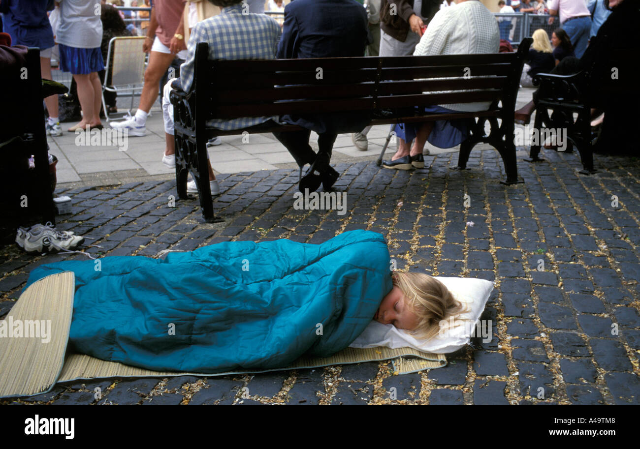 Young girl spectator sleeping in blue sleeping bag on pavement at Royal ...