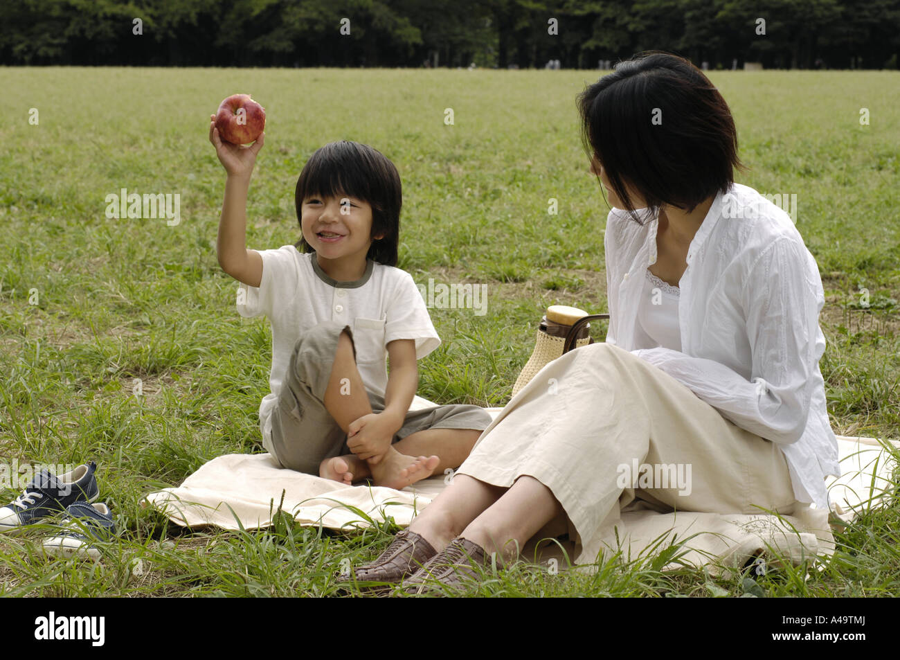 Young woman sitting with her daughter on a mat Stock Photo - Alamy
