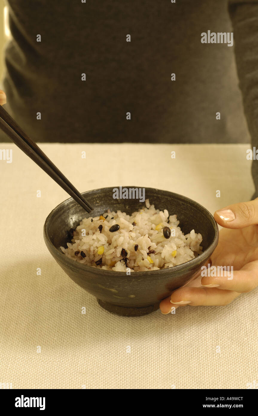 Mid section view of a woman holding a Bowl of rice Stock Photo - Alamy
