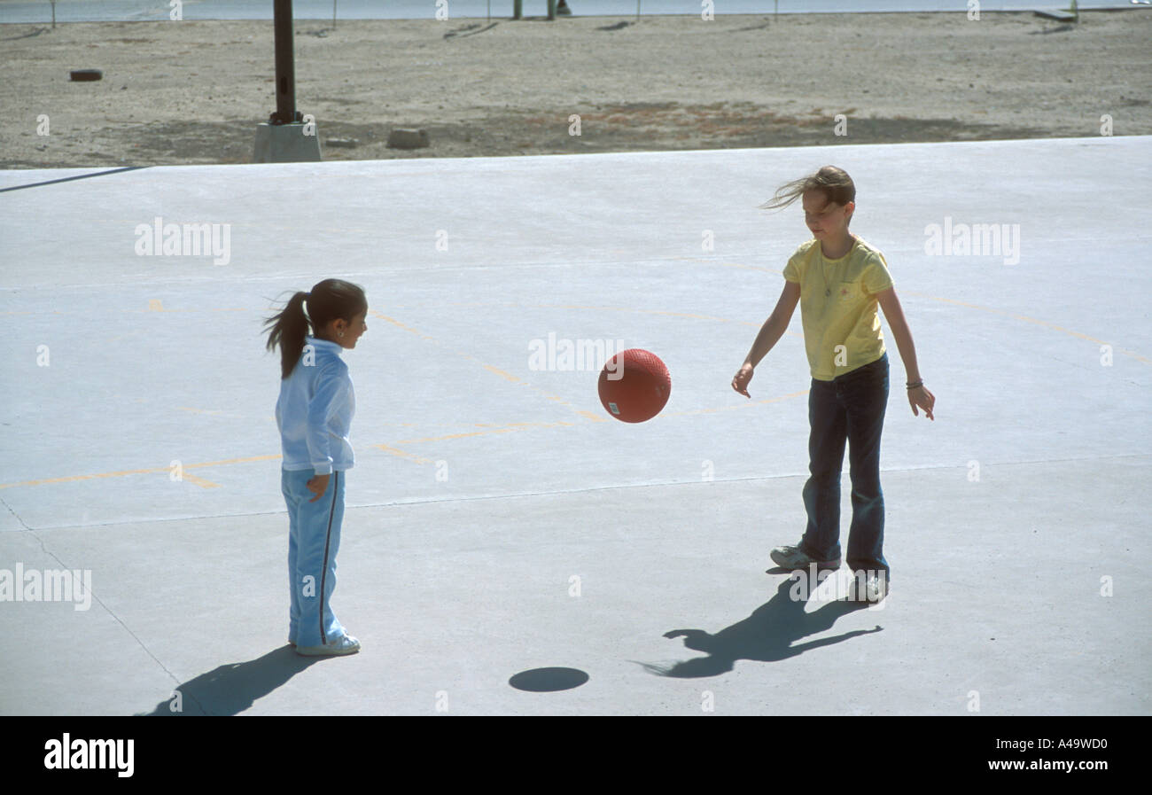 Two girls play with a ball at a city park in Juarez Mexico Stock Photo ...
