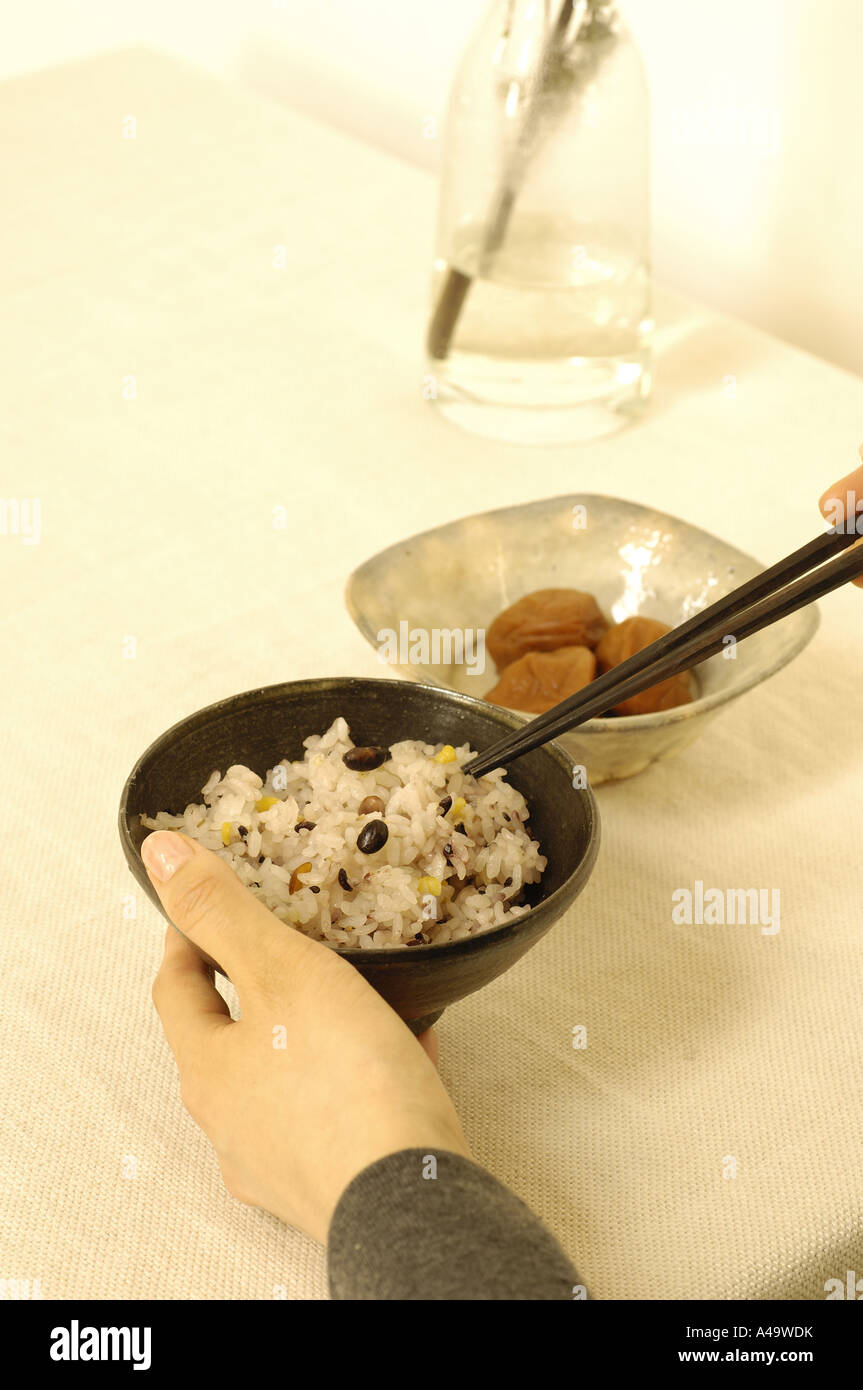 Close up of a woman s hand holding a Bowl of rice Stock Photo - Alamy