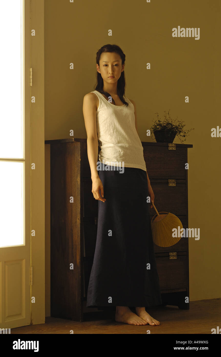 Portrait of a young woman holding a fan Stock Photo - Alamy