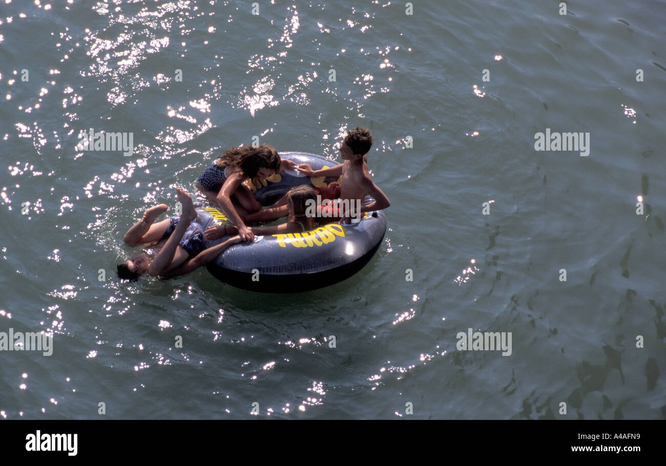 Children playing in inflated tyre inner tube on sea Stock Photo - Alamy