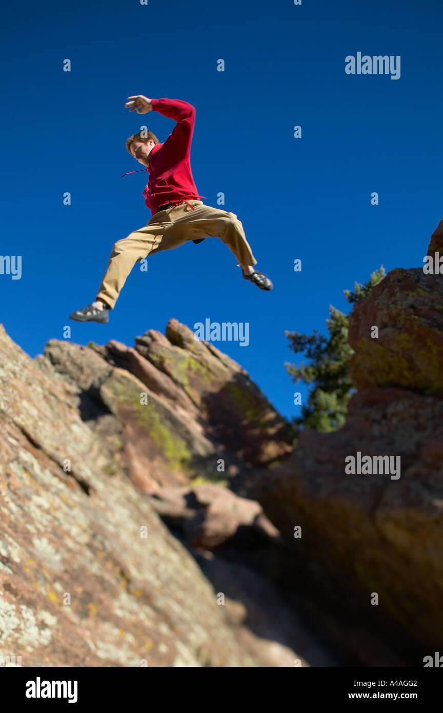 caucasian Man leaps across large distance while bouldering in Boulder ...