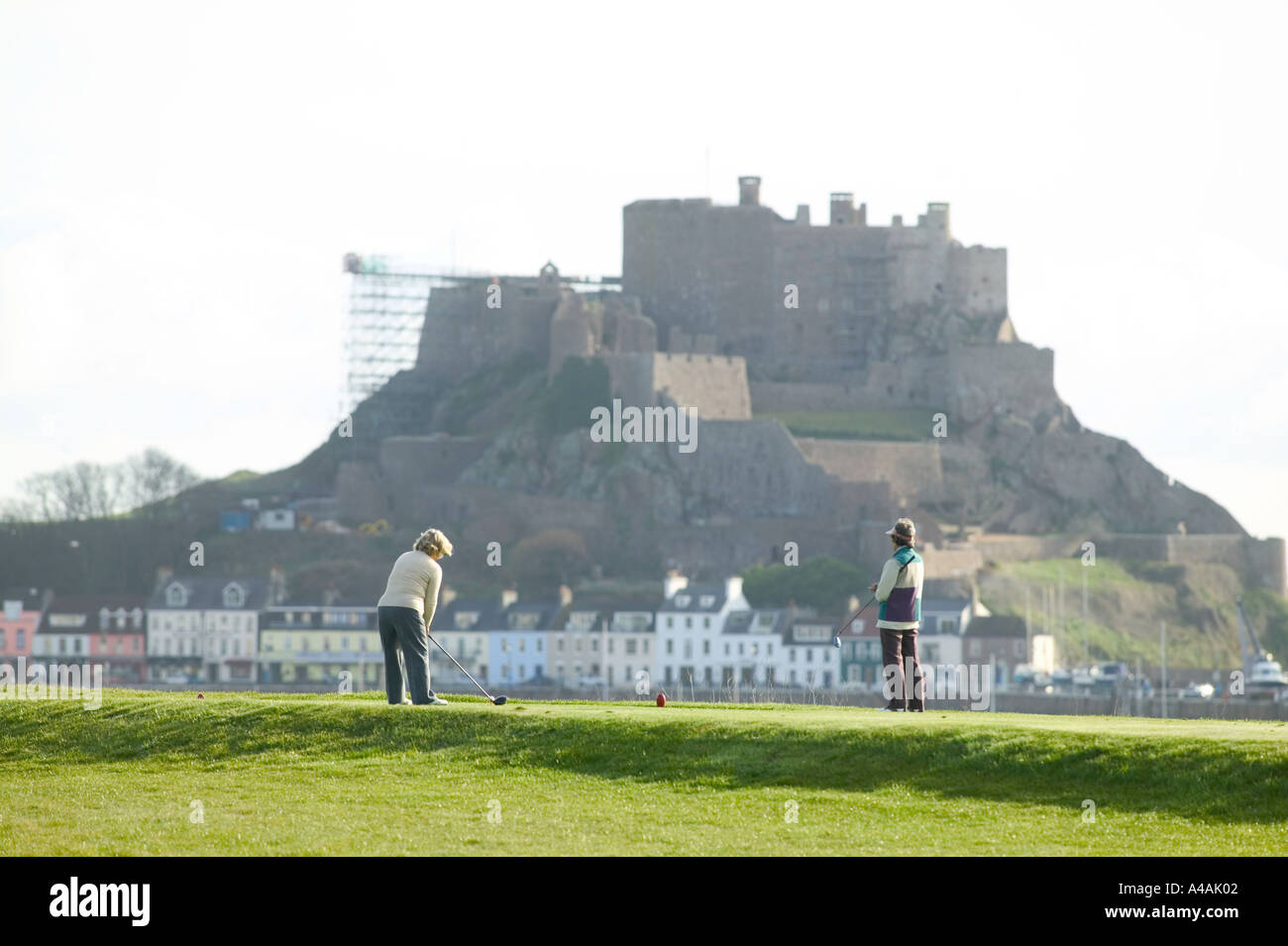 Golf players playing on the Royal Jersey Golf course with Gorey castle ...