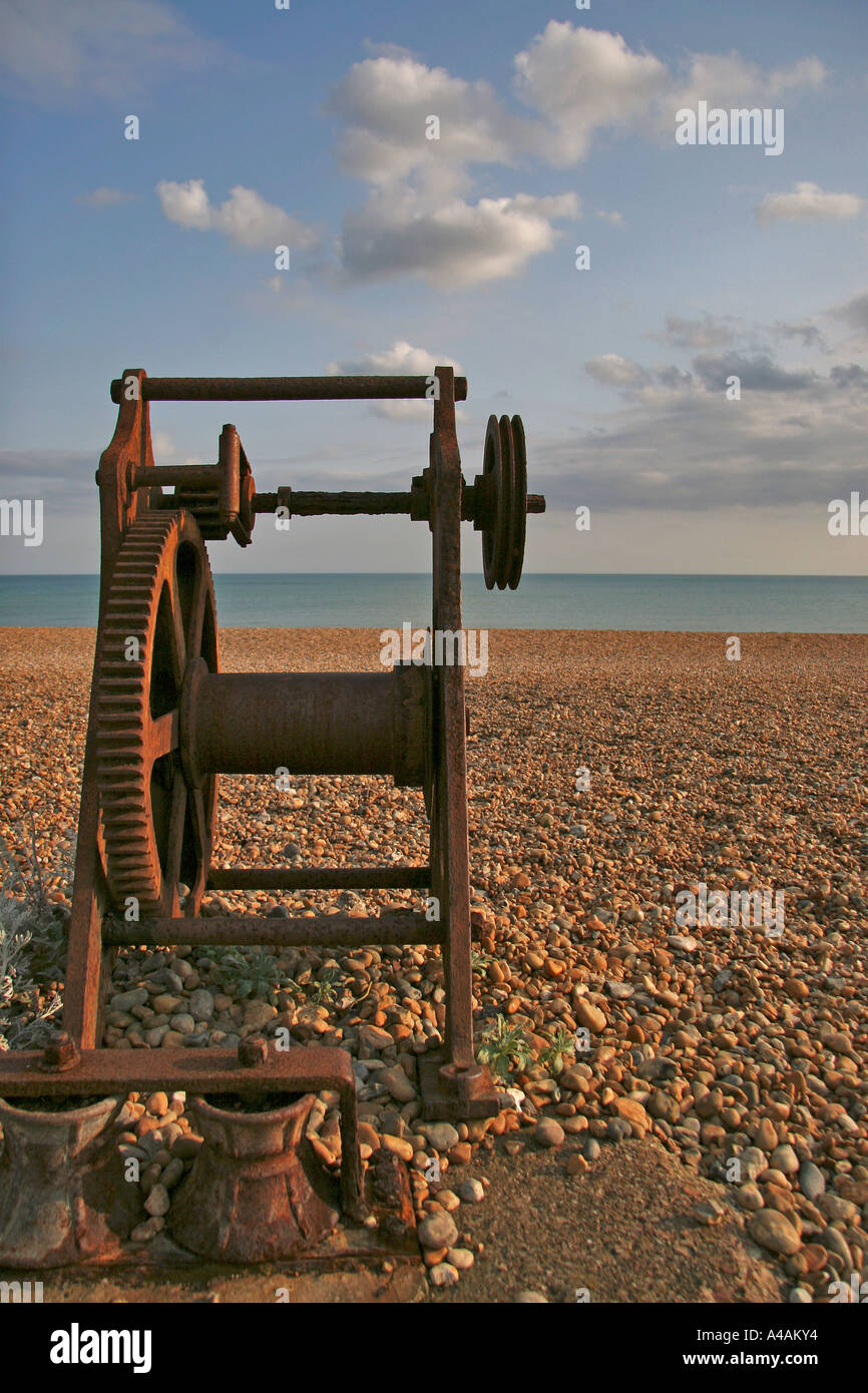 A rusty old iron winch for pulling boats up on to the pebble beach near ...